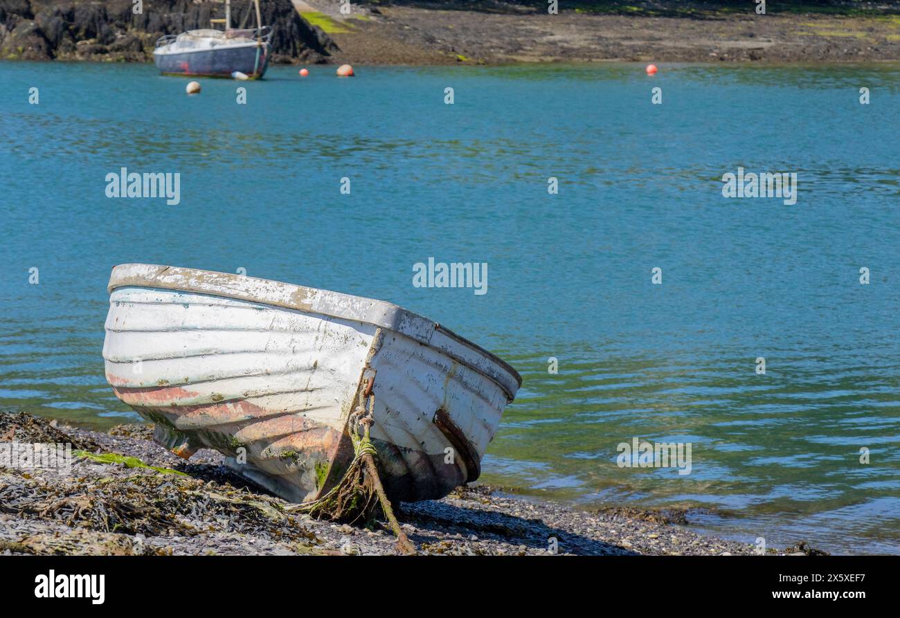Fibreglass boat pulled up onto shingle beach Stock Photo - Alamy