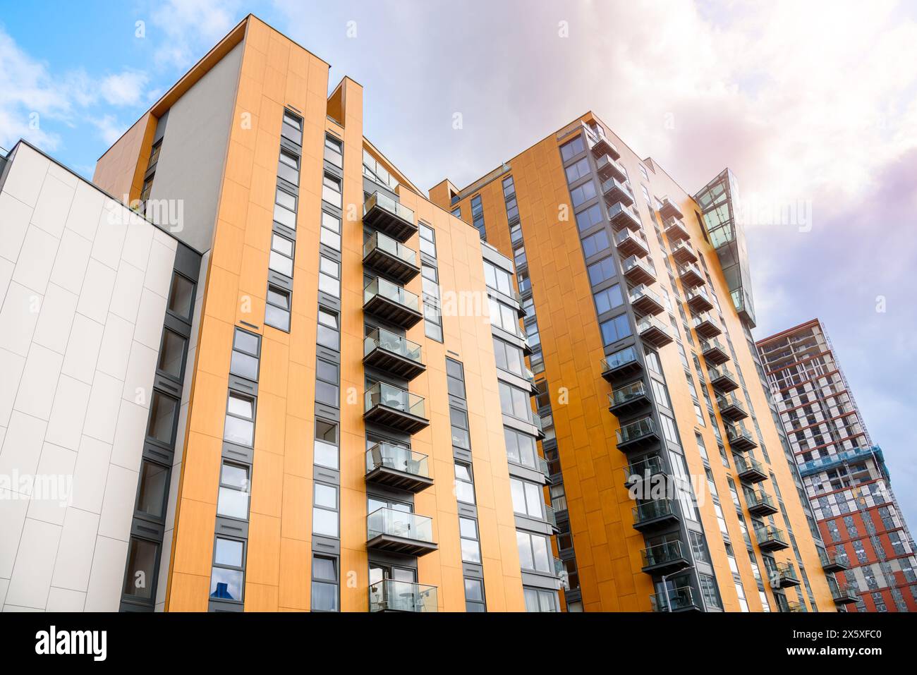 Modern high rise blocks of flats under partly cloudy sky in summer. A ...