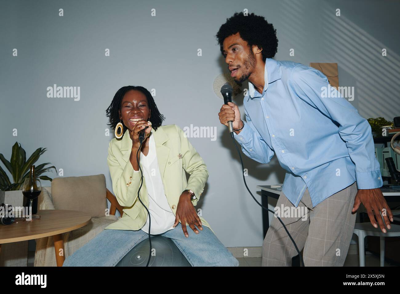 Happy office workers singing in microphones after work Stock Photo - Alamy