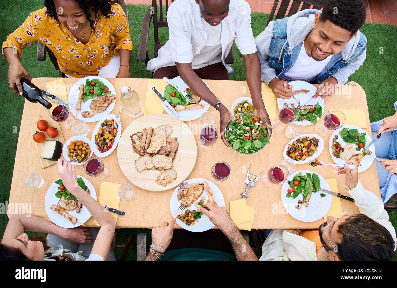 Top view from above of gathering happy people around meal table with ...