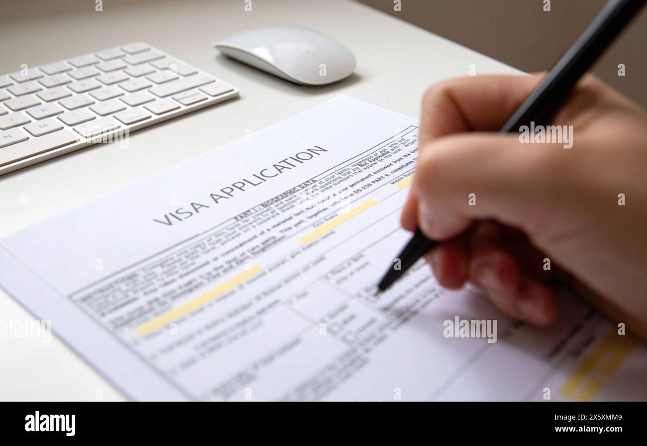 Close up of a female hand filling out a visa application document Stock ...