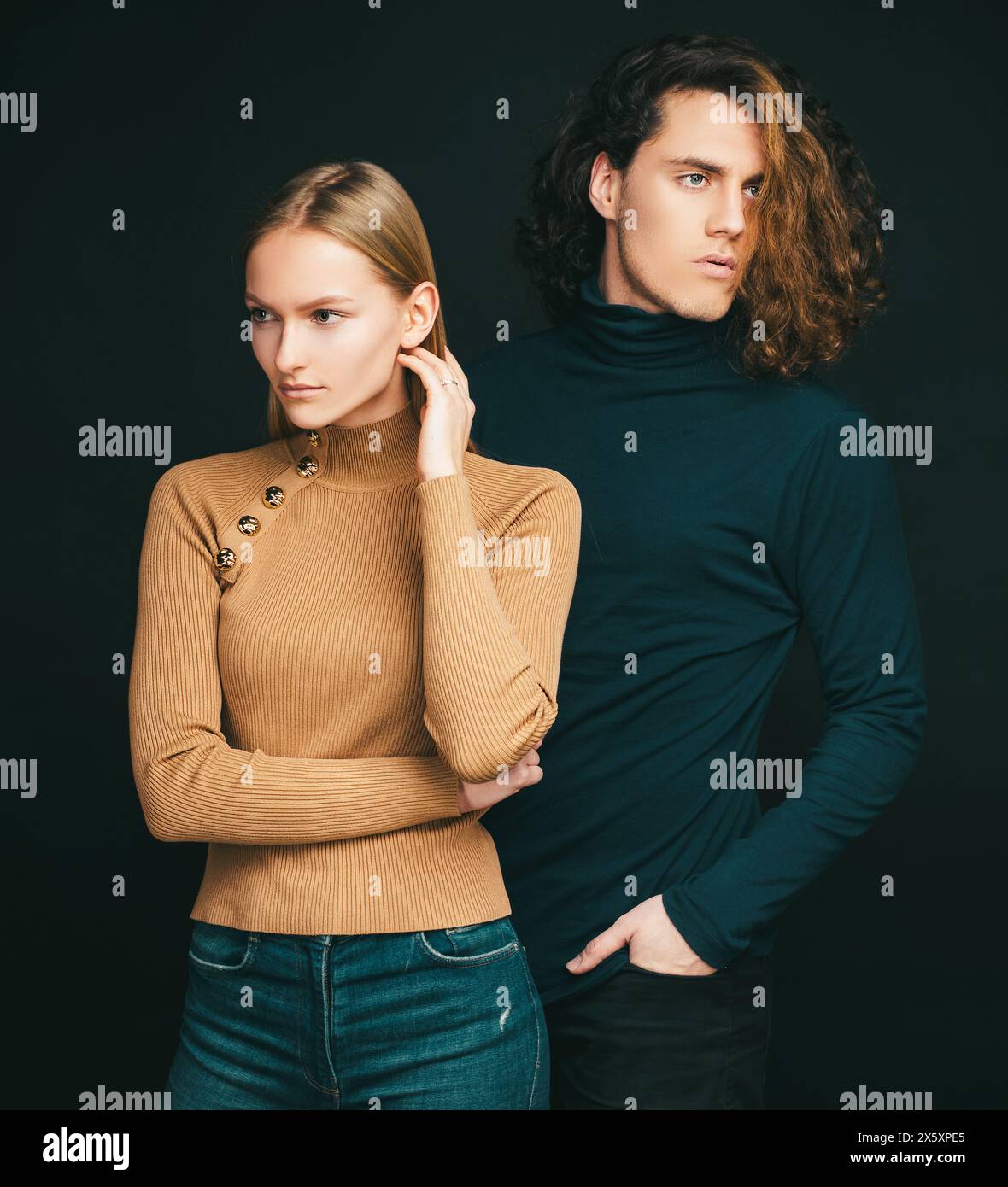 Concentrated girl standing next to a curly boyfriend. Attractive couple ...