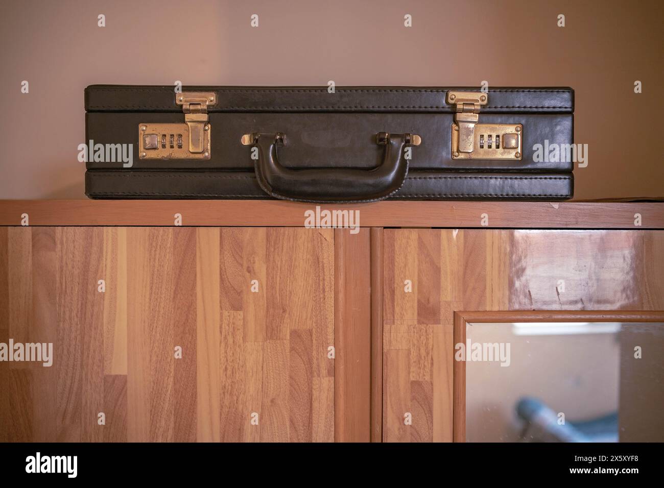 Briefcase with lock on the cupboard Stock Photo - Alamy