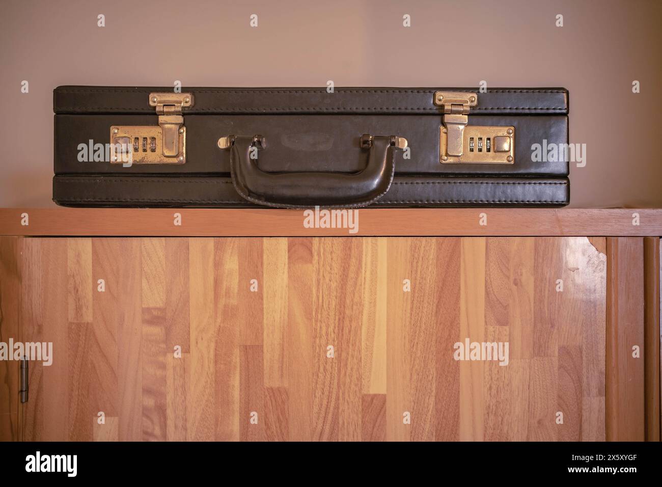 Briefcase with lock on the cupboard Stock Photo - Alamy