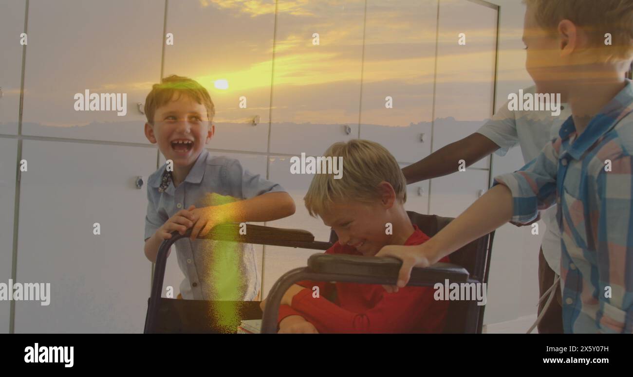 Image of sunset landscape over happy diverse schoolboys pushing friend ...