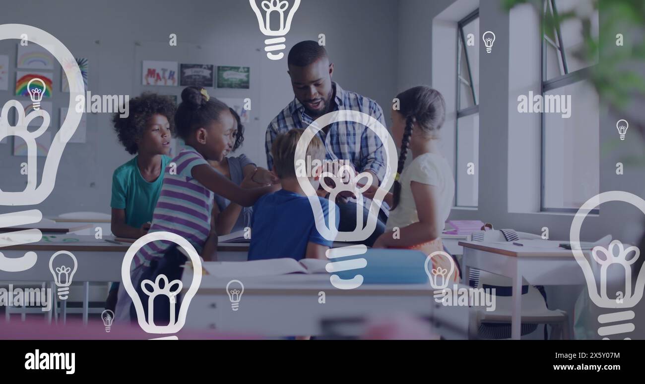 Image of light bulbs over diverse male teacher and pupils studying ...