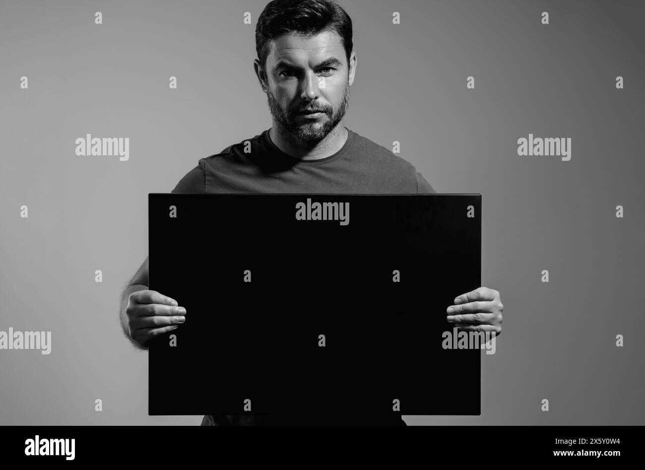 Serious business man holding empty board. Successful businessman ...