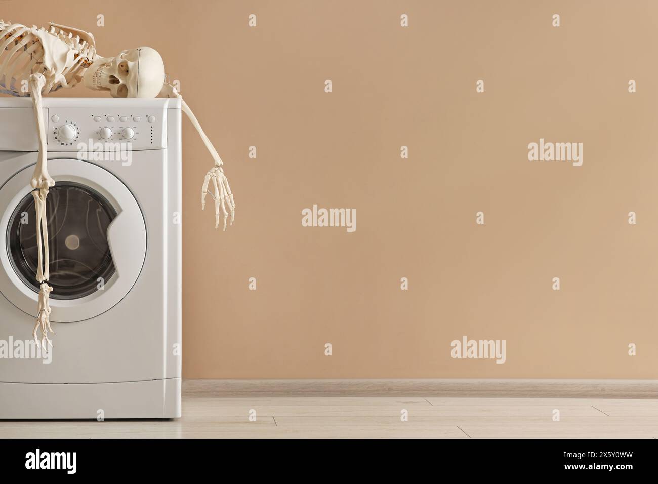 Waiting concept. Human skeleton lying on washing machine near beige ...