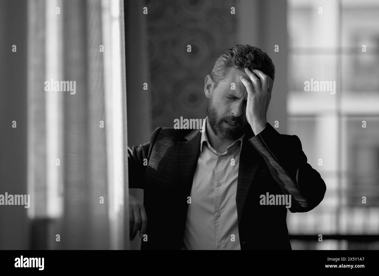 Headache, tiredness and stress. Close up portrait of man in suit got ...