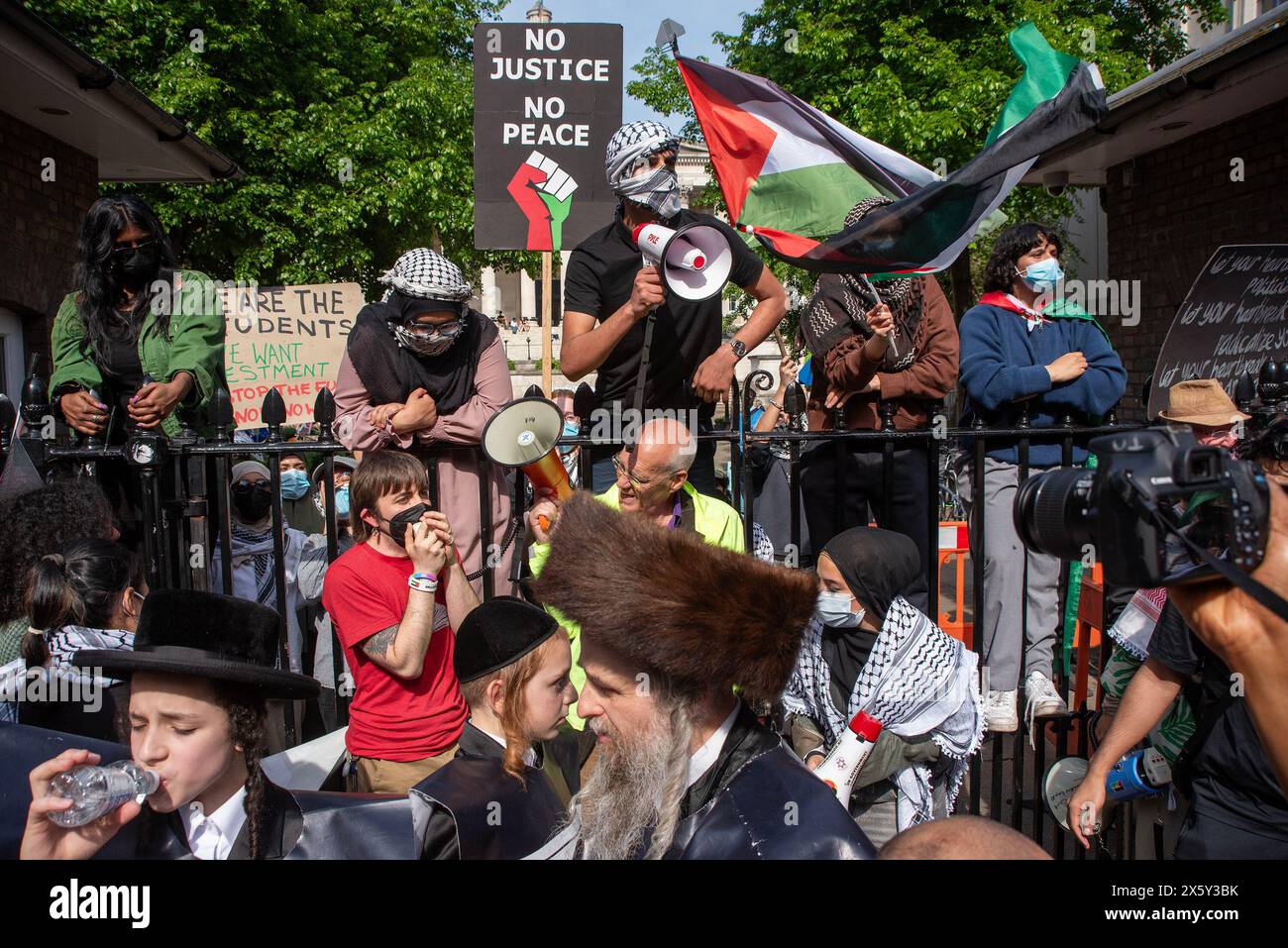 London, UK. 11th May, 2024. UCL students stand inside the gate and wave ...