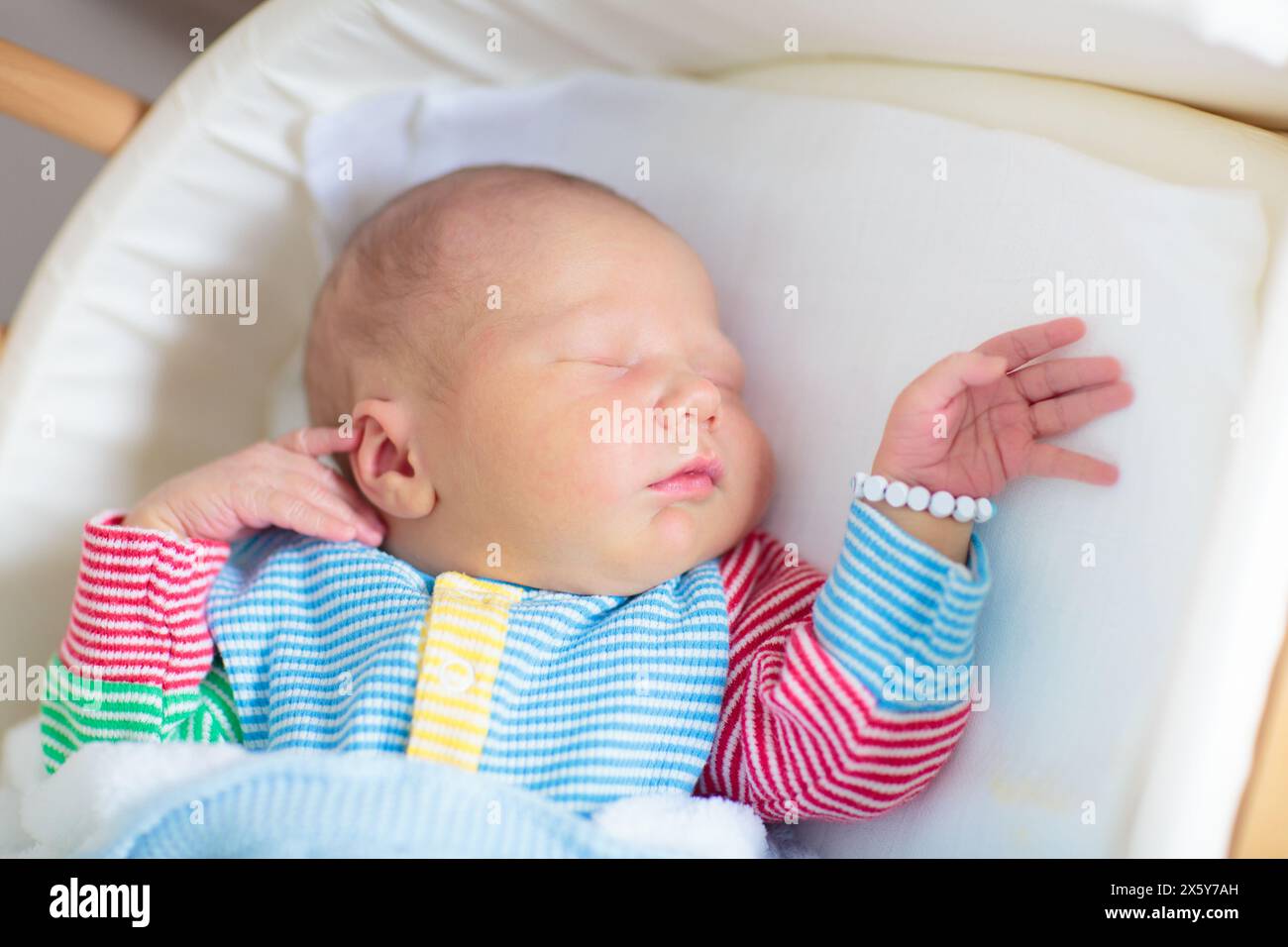 Newborn baby in hospital room. New born child in wooden co-sleeper crib ...