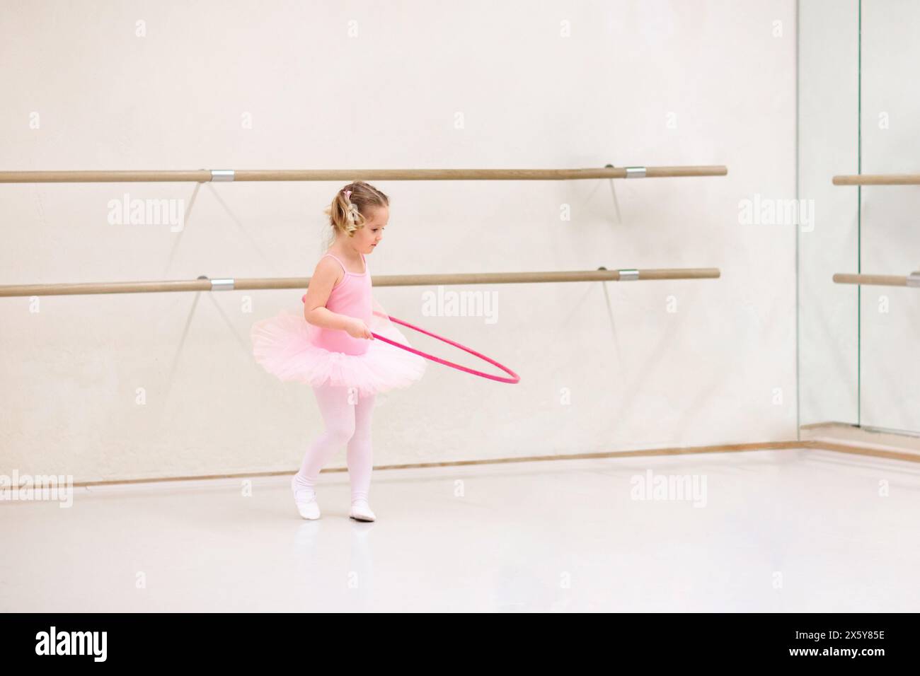 Little ballerina girl in a pink tutu. Adorable child dancing classical ...