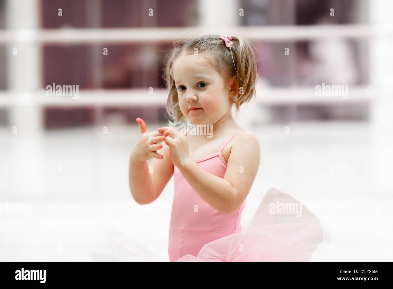 Little ballerina girl in a pink tutu. Adorable child dancing classical ...