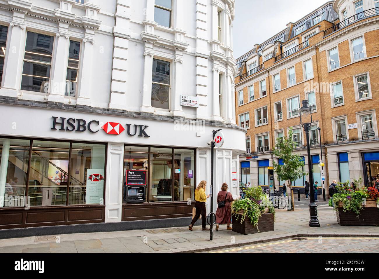 Branch of british bank HSBC UK in Covent Garden London, bank logo visible, two women walk past ...