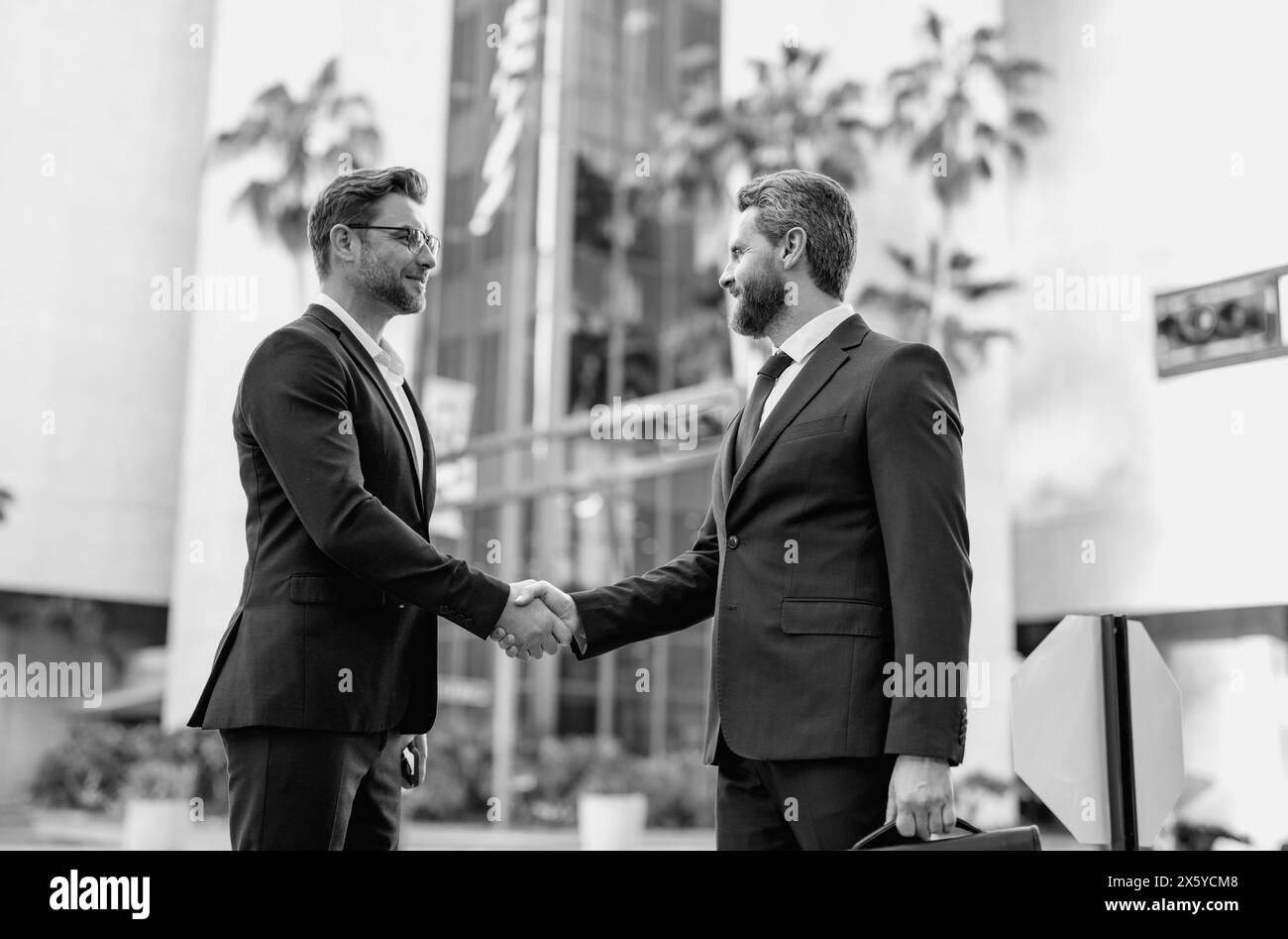 American businessman shaking hands with partner. Handshake between two ...