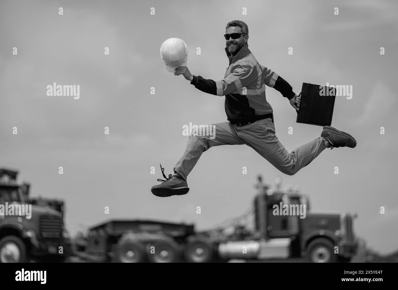 Middle aged builder excited jump on site construction. Excited builder ...