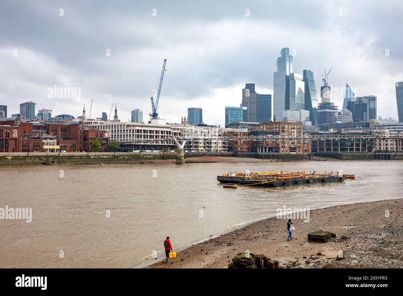 River Thames at low tide with people walking along the bank of the ...