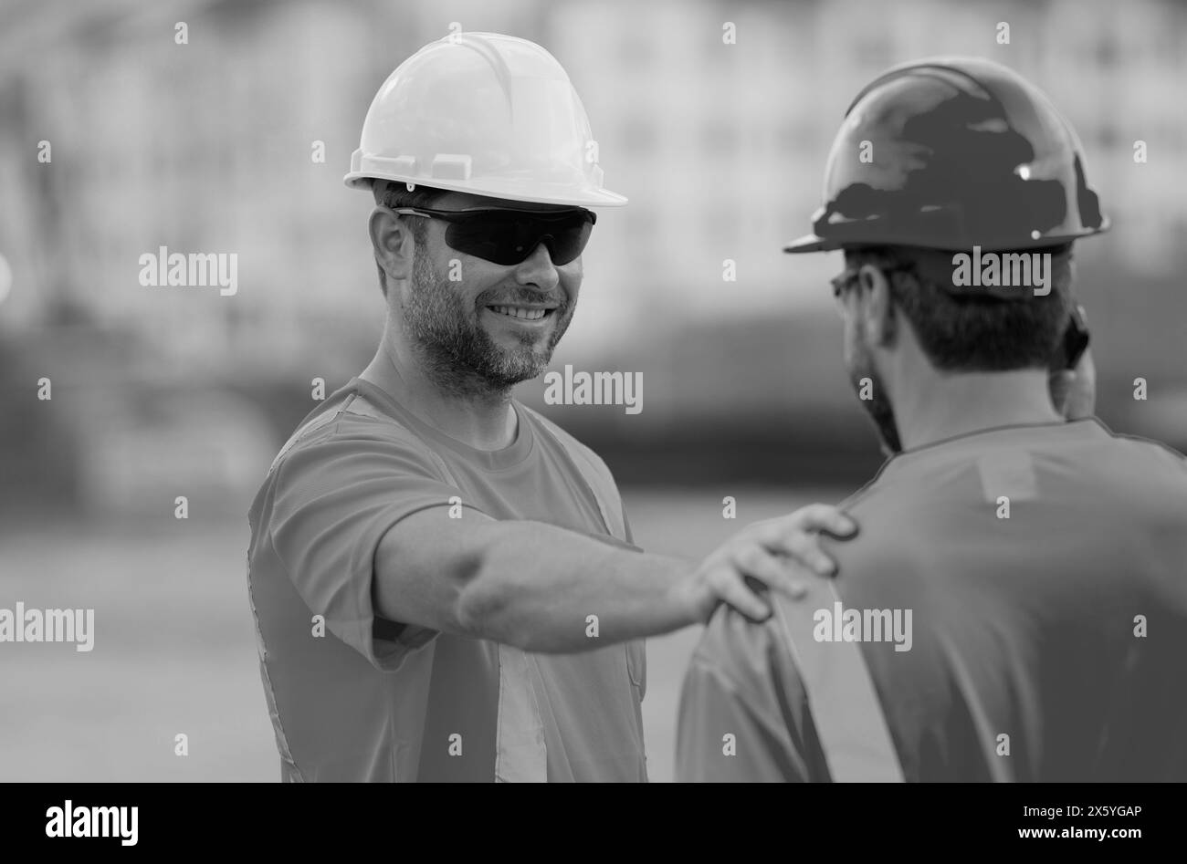 Construction site workers in a helmet work hard. Two workers in a hard ...