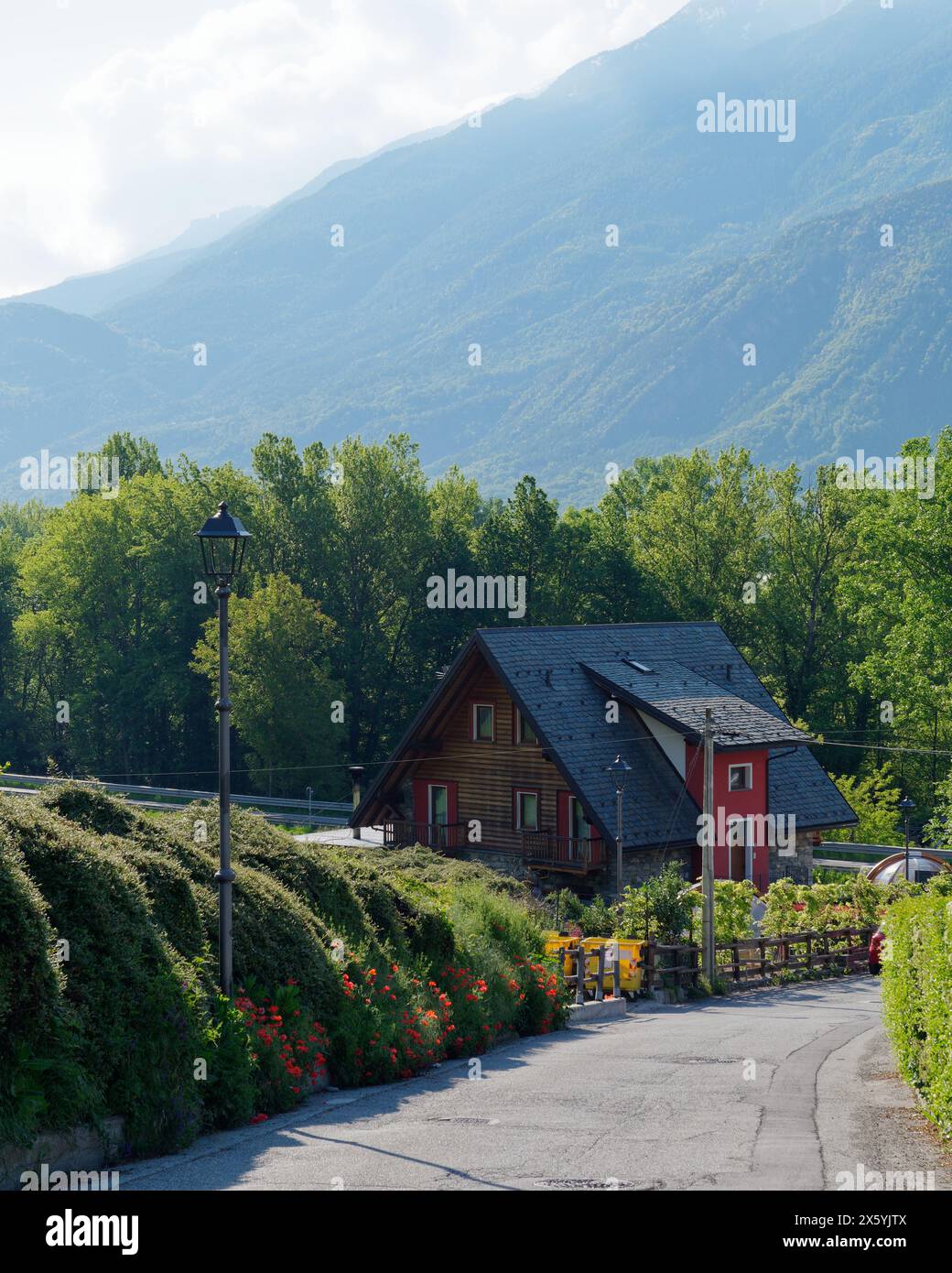 Rural roadside cafe/restaurant with hedge in front and mountain behind ...