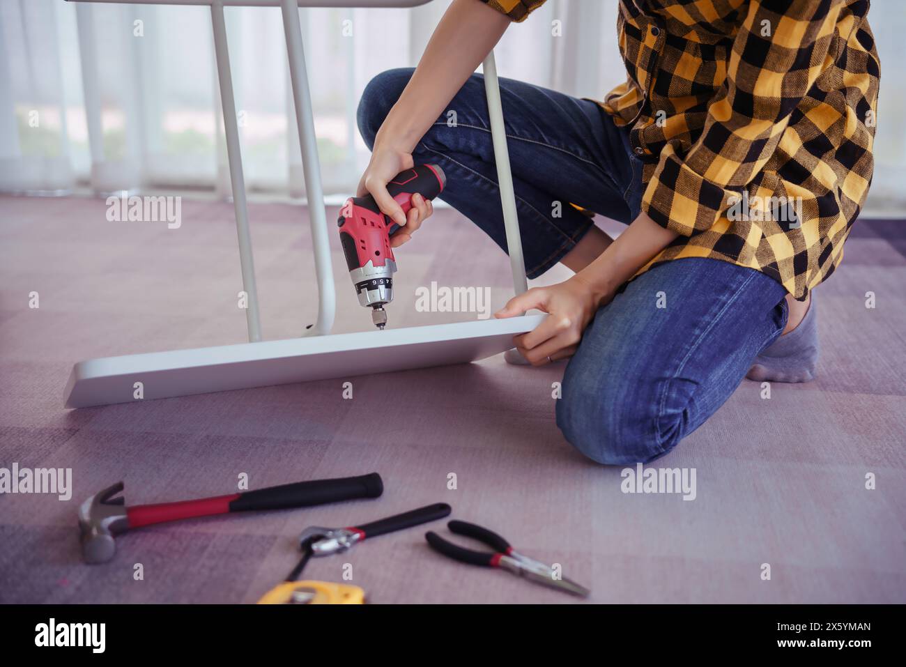 Women use electric screwdriver to installation screw and assembling ...