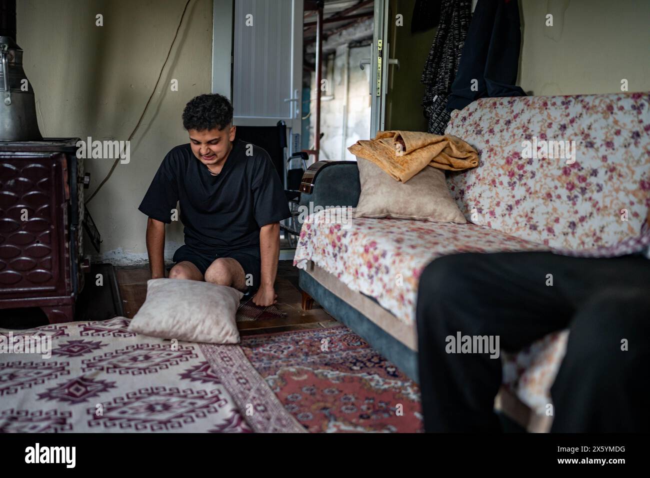 Onur walks in the living room of his house after removing his ...