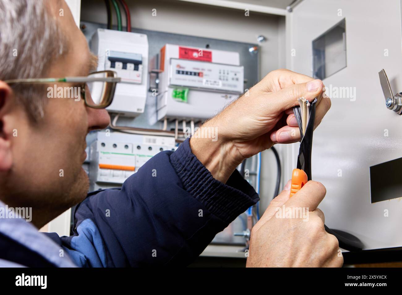 Removing outer sheath of PVC insulation from power cable for connection ...