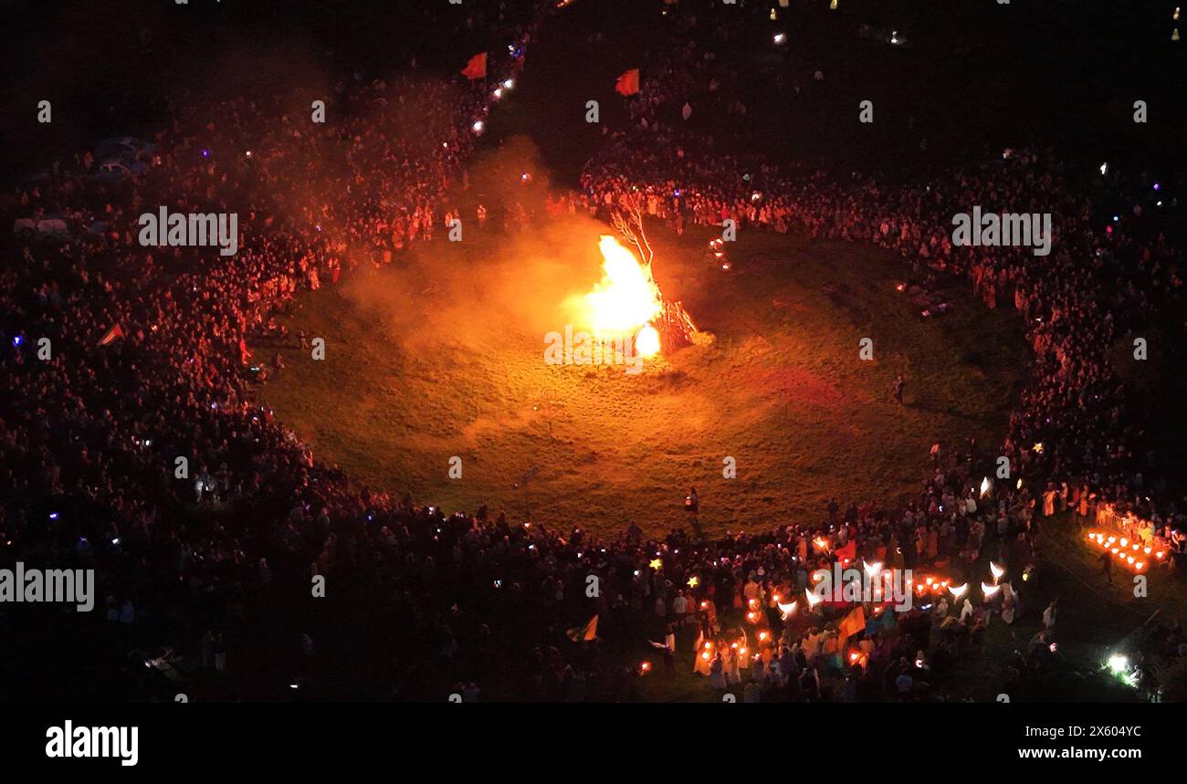 A crowd of just under 5000 people gathers around a huge bonfire during ...