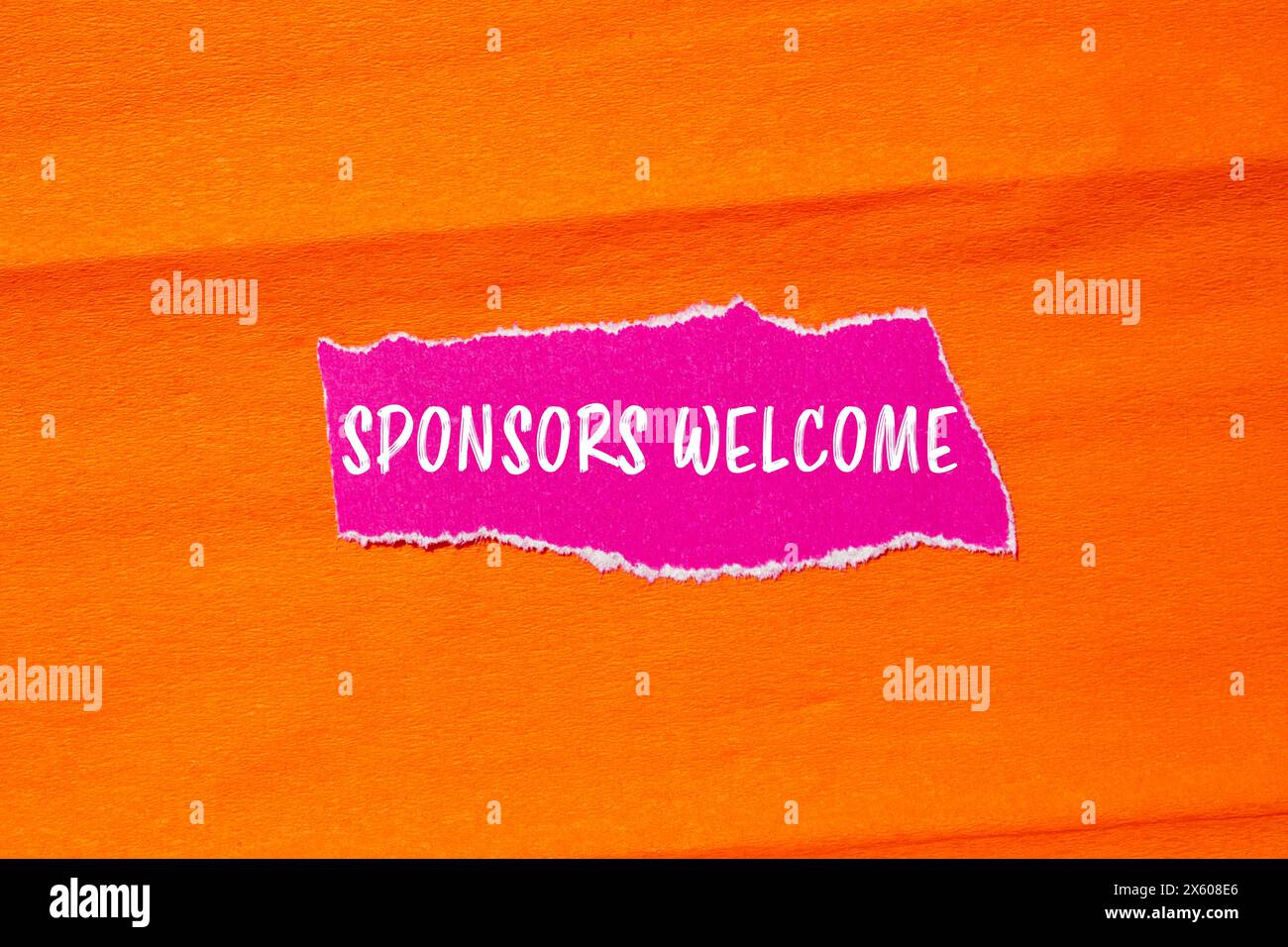 Sponsors welcome words written on ripped pink paper piece with orange ...