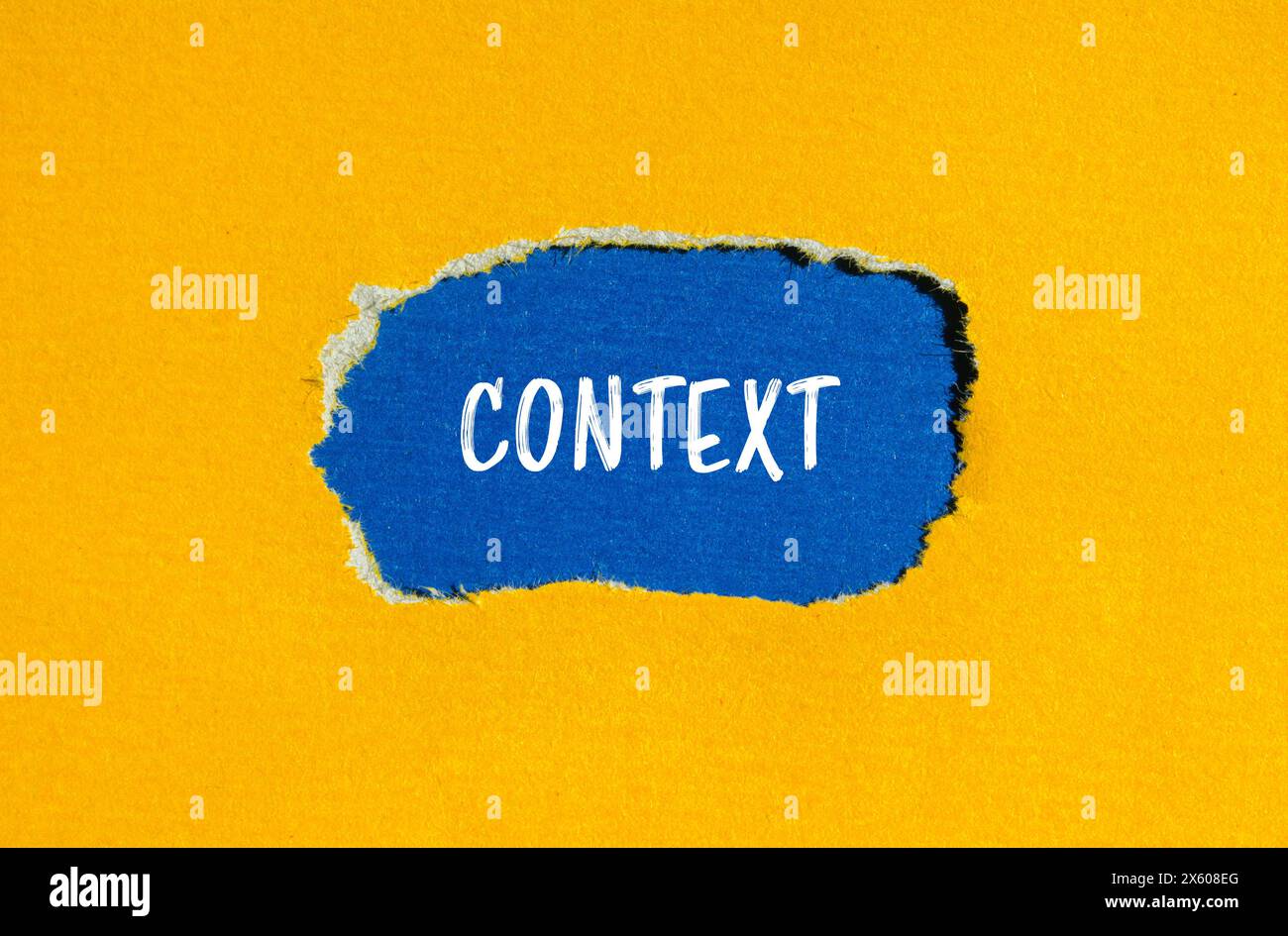 Context word written on ripped yellow paper with blue background ...