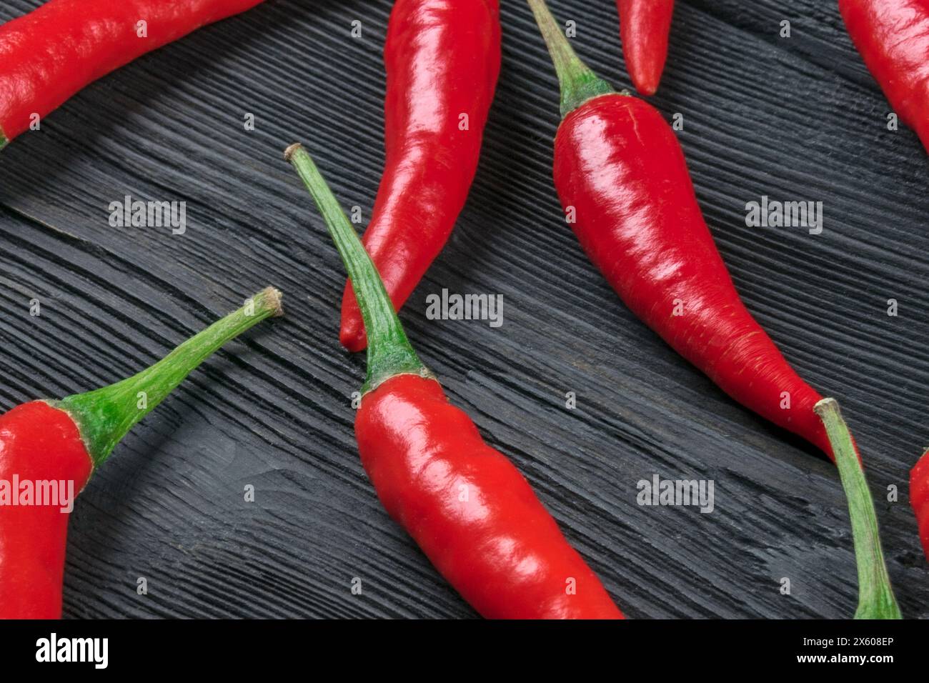 Red chili pepper on the black wooden table background Stock Photo - Alamy