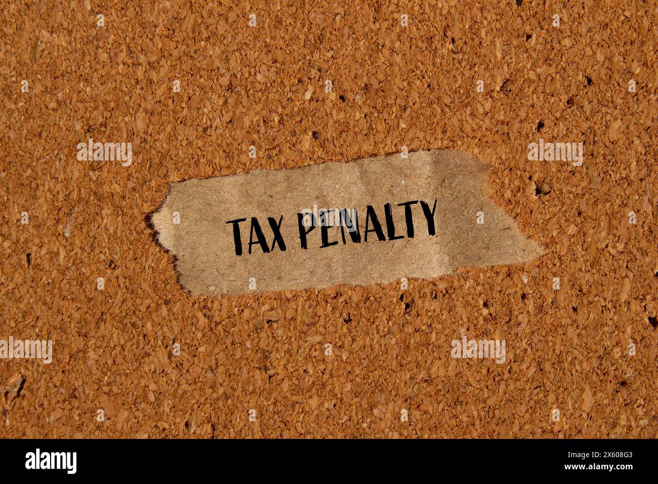 Tax penalty words written on ripped paper piece with brown background ...