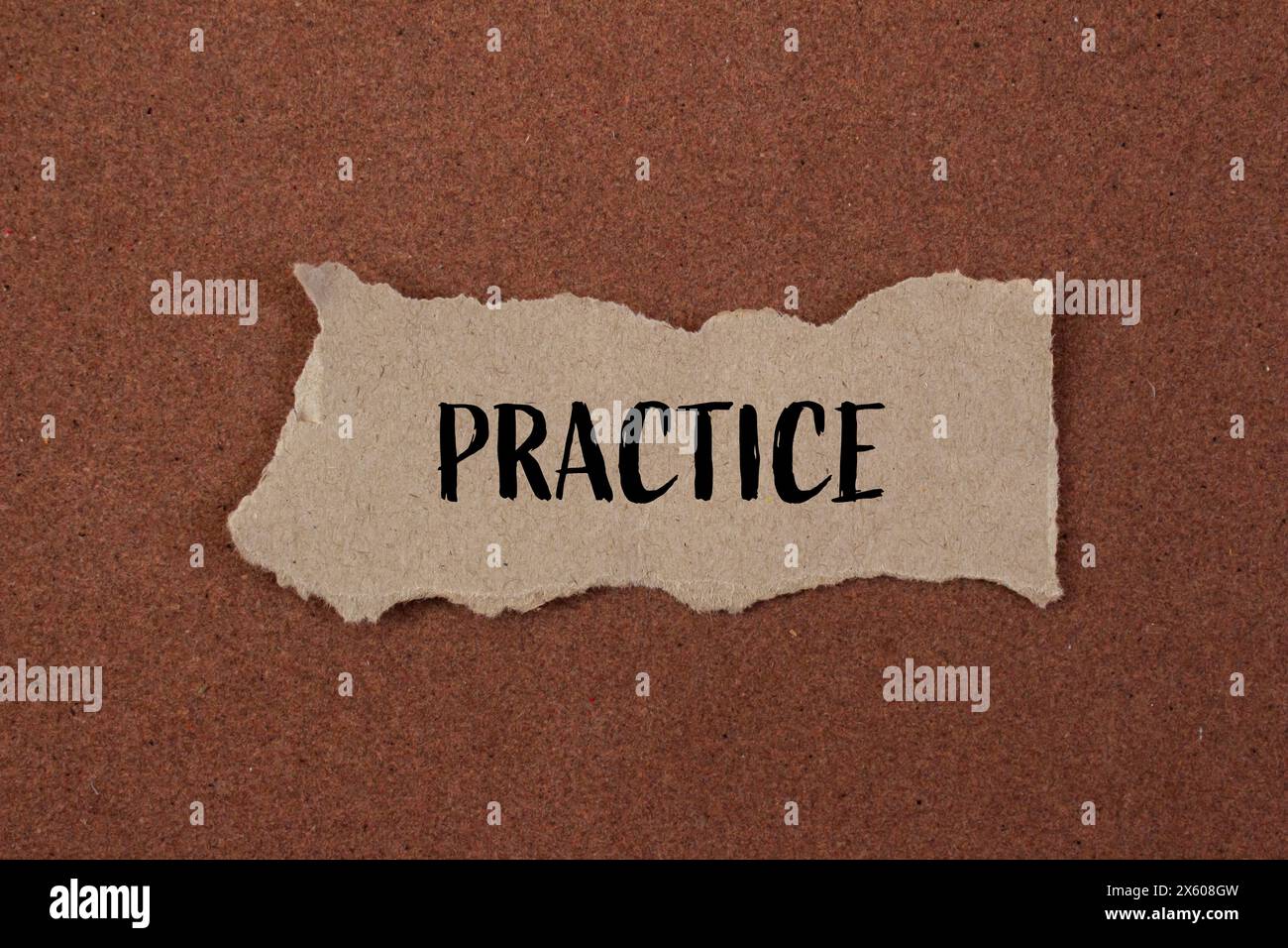 Practice word written on ripped paper piece with brown background ...