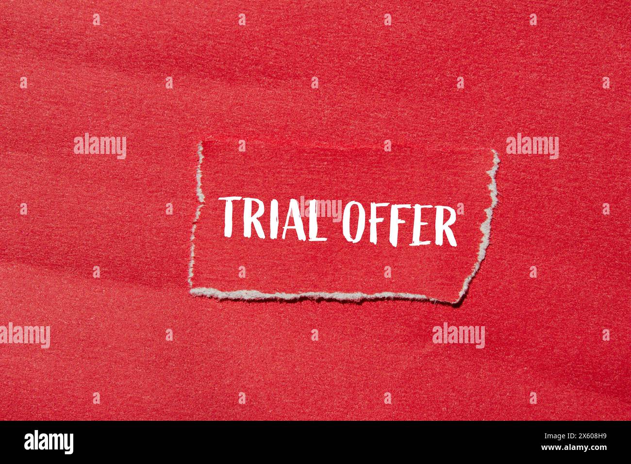Trial offer words written on ripped red paper with red background ...