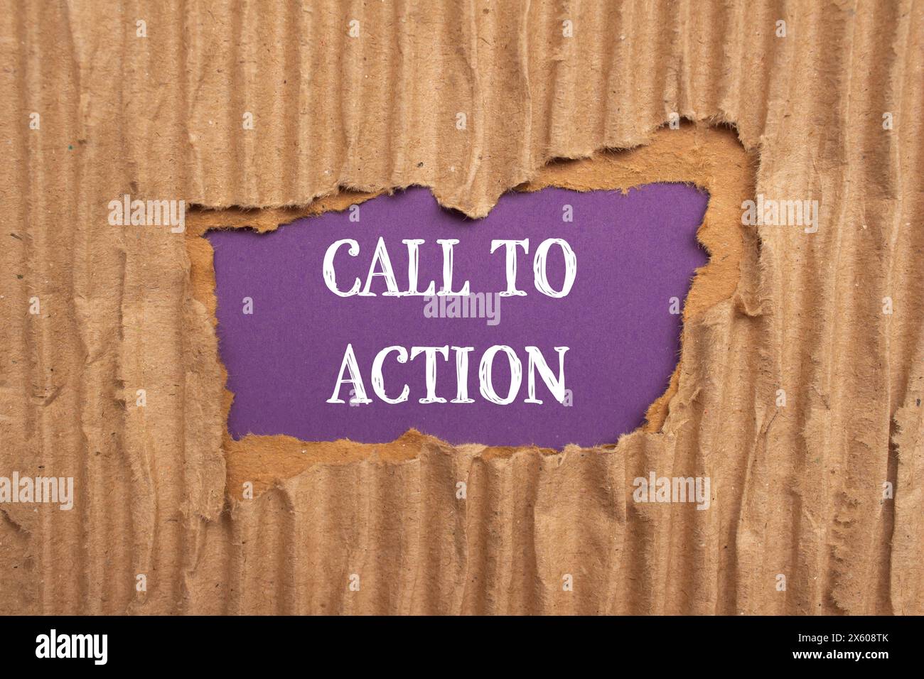 Call to action words written on ripped cardboard paper with purple ...