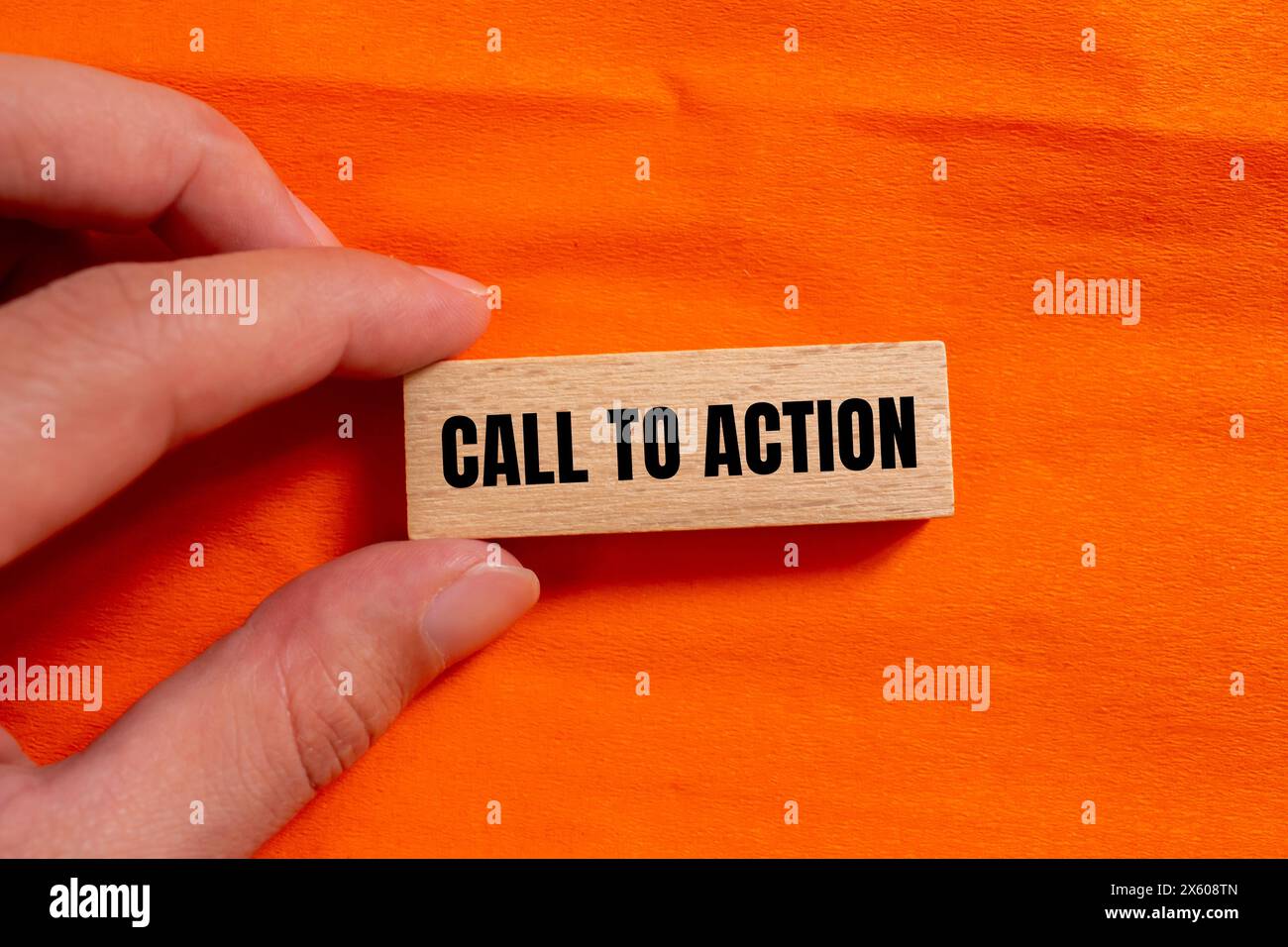 Call to action words written on wooden block with orange background ...