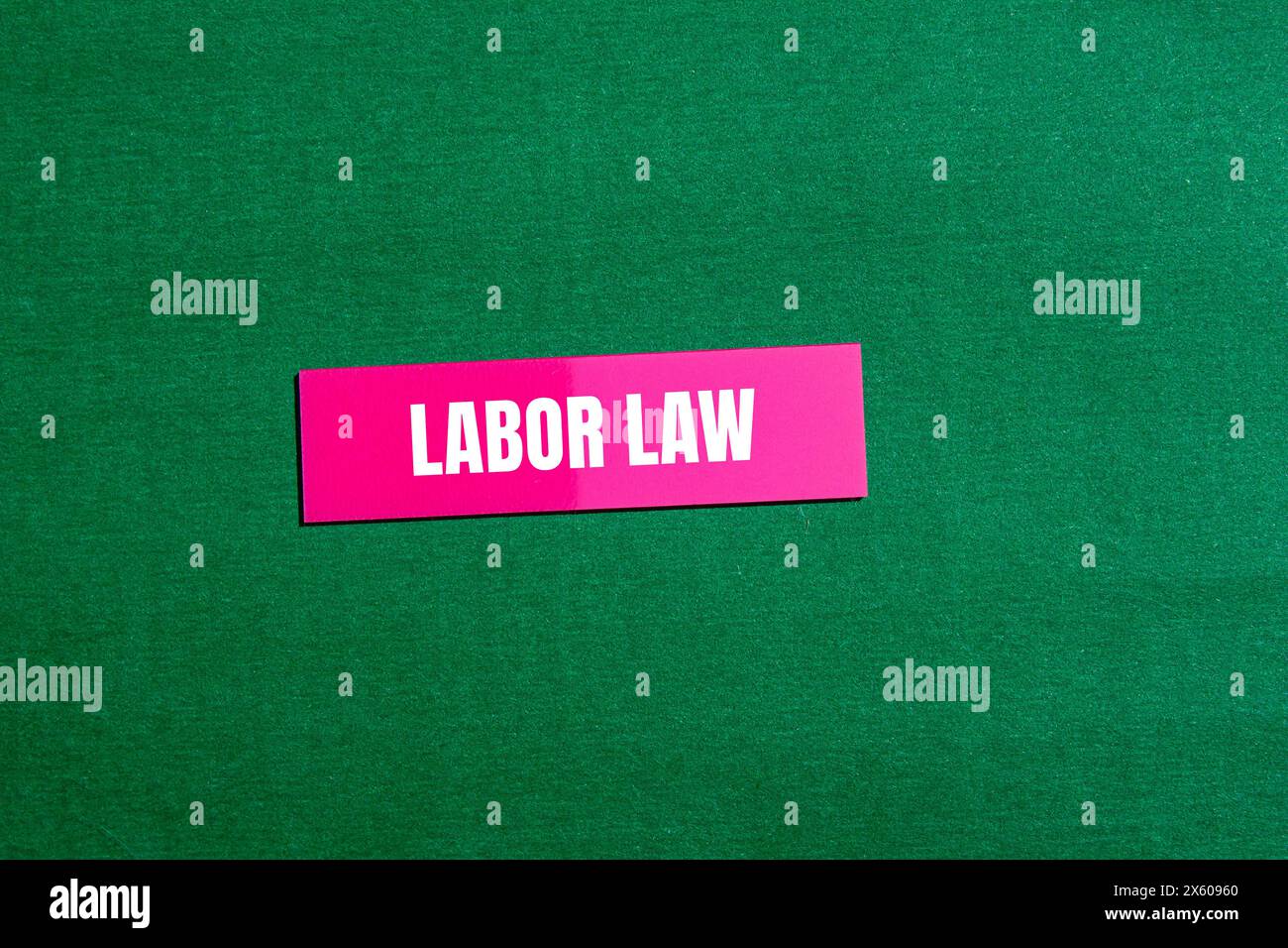 Labor law words written on pink paper sticker with green background ...