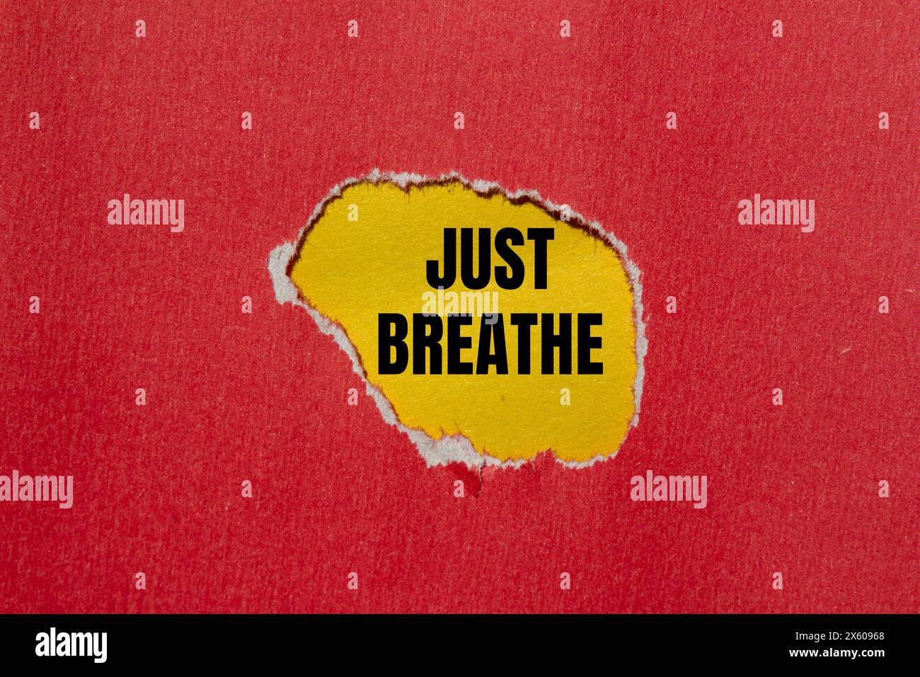 Just breathe words written on ripped red paper with yellow background ...