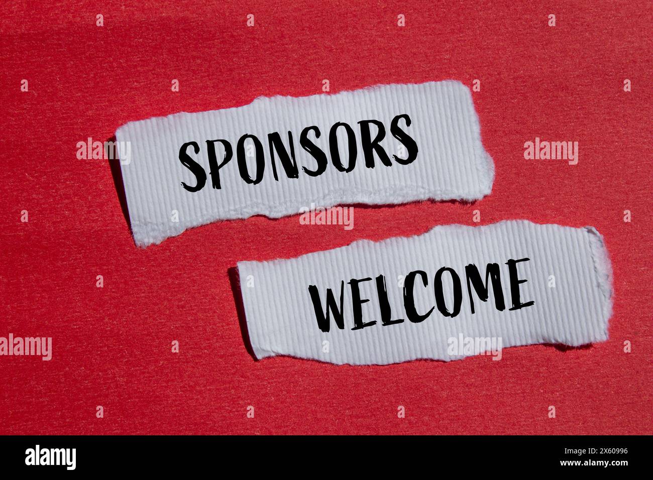 Sponsors welcome words written on ripped white paper pieces with red ...