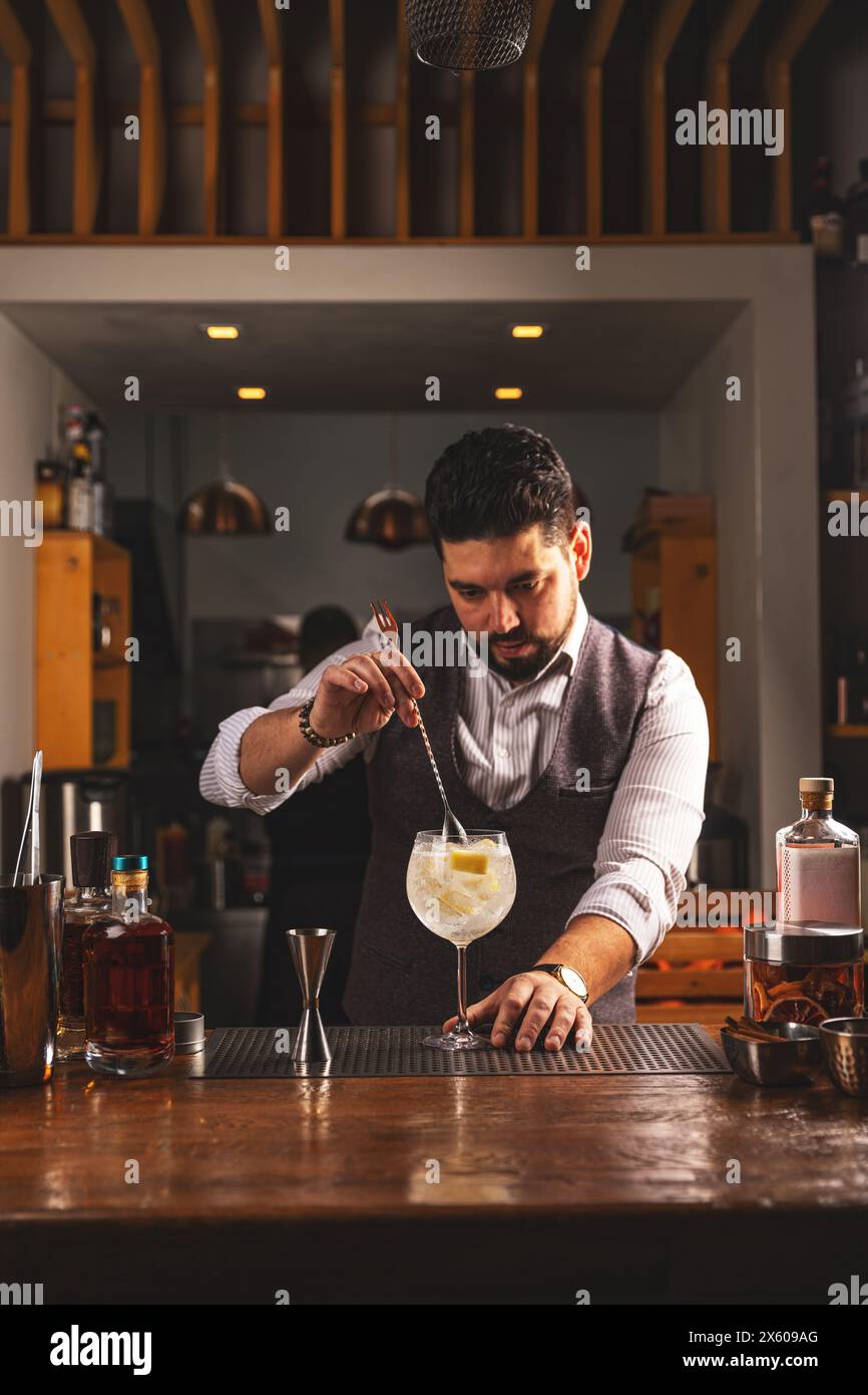 Expert bartender carefully adding a garnish to a crafted cocktail in a ...