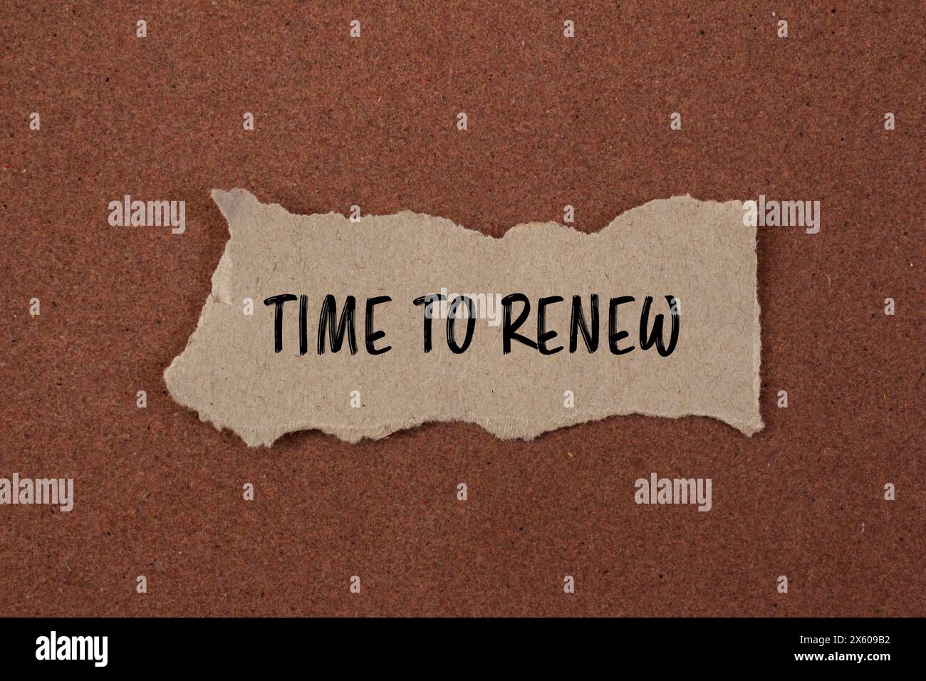 Time to renew words written on ripped paper piece with brown background ...