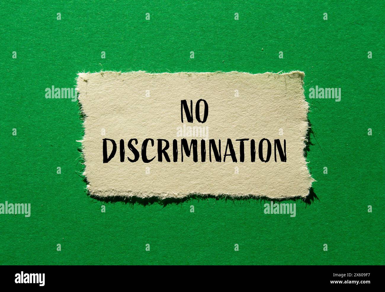 No discrimination words written on ripped paper with green background ...