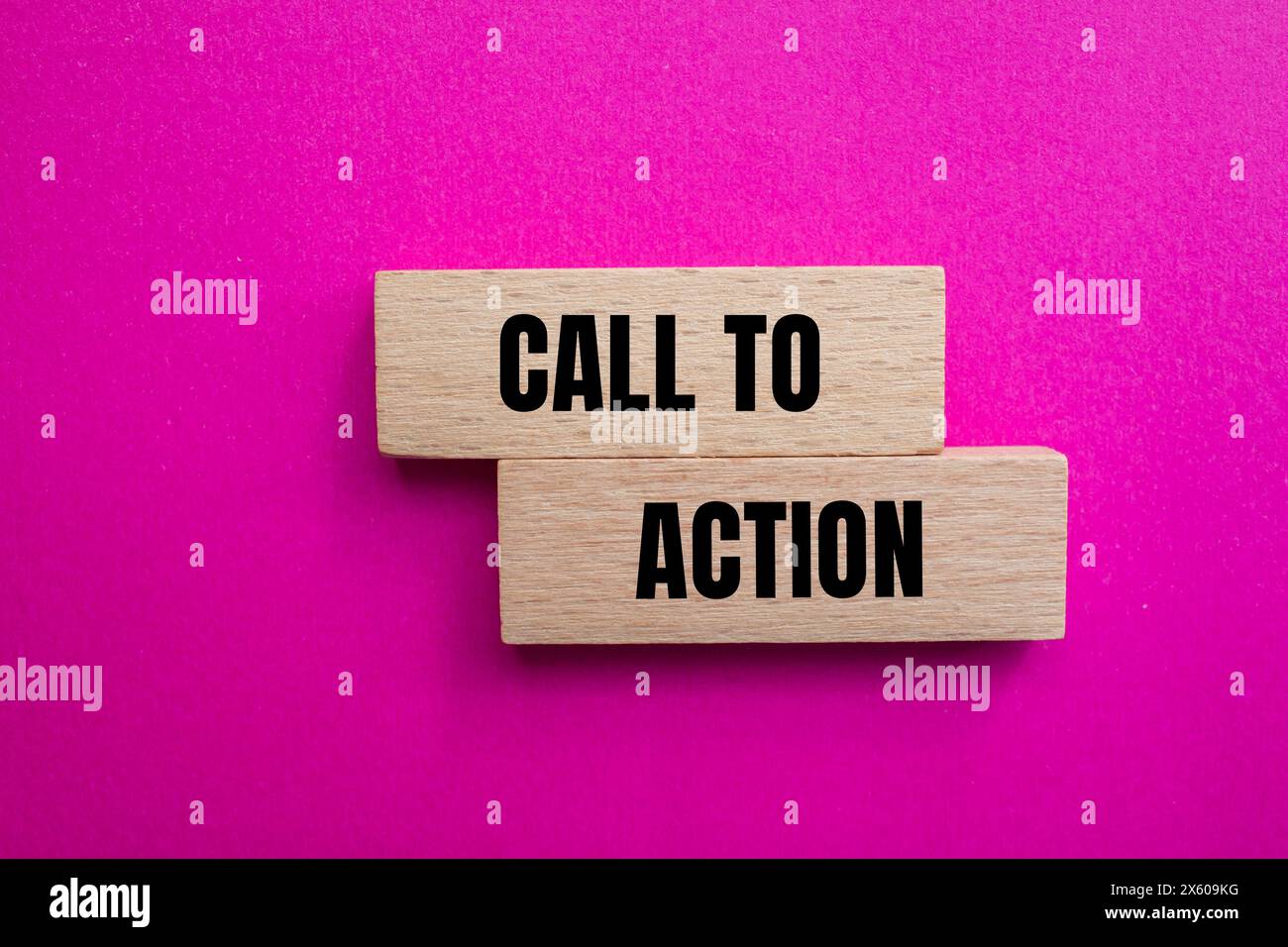 Call to action words written on wooden blocks with pink background ...