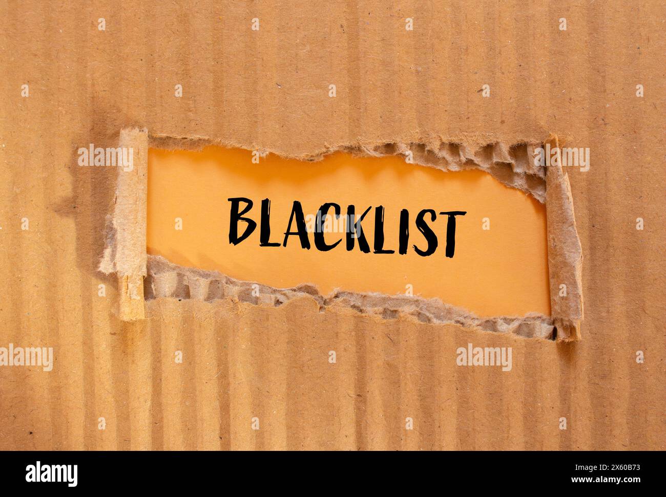 Blacklist word written on ripped cardboard paper with orange background ...