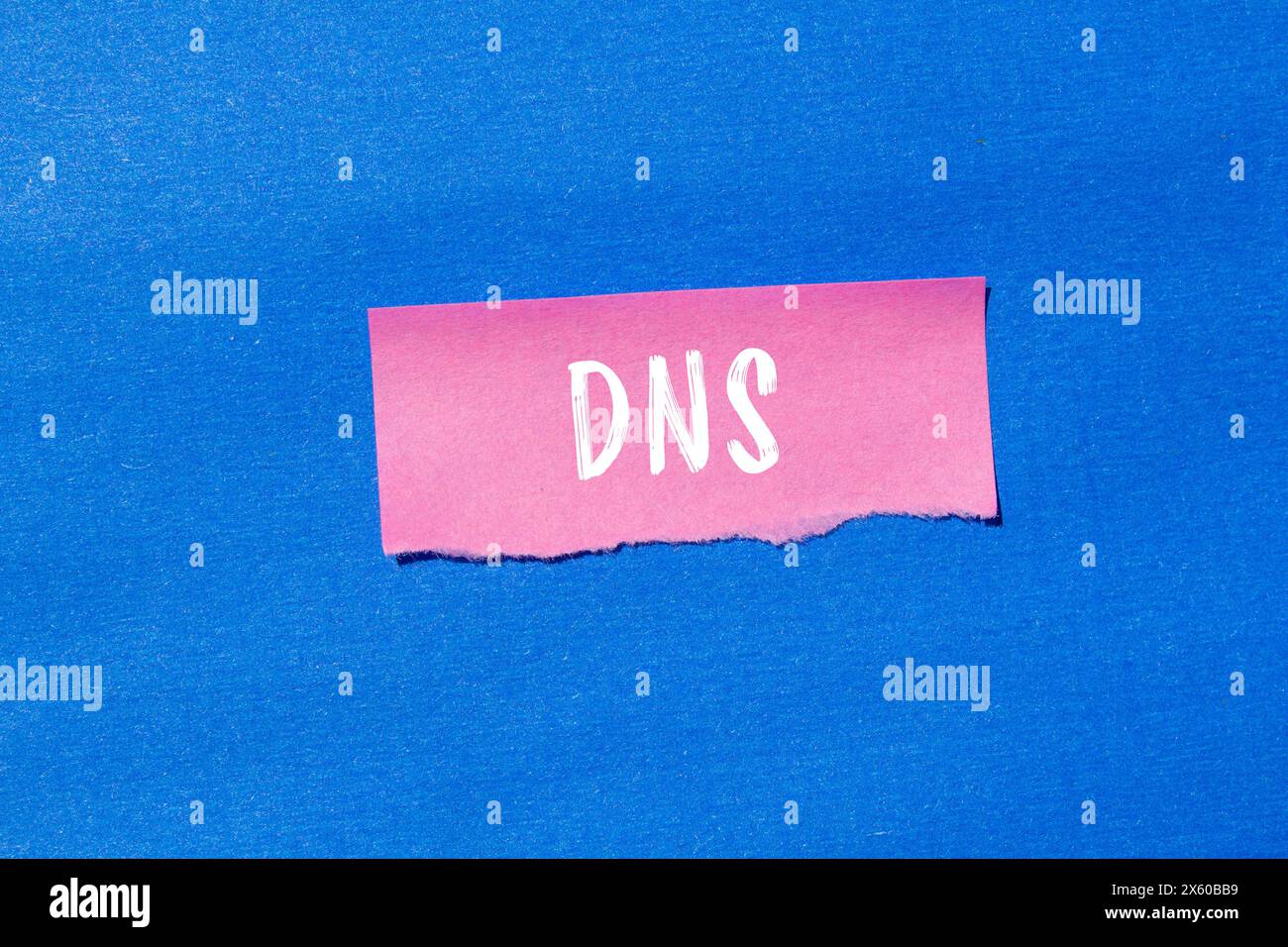 DNS word written on ripped pink paper with blue background. Conceptual ...