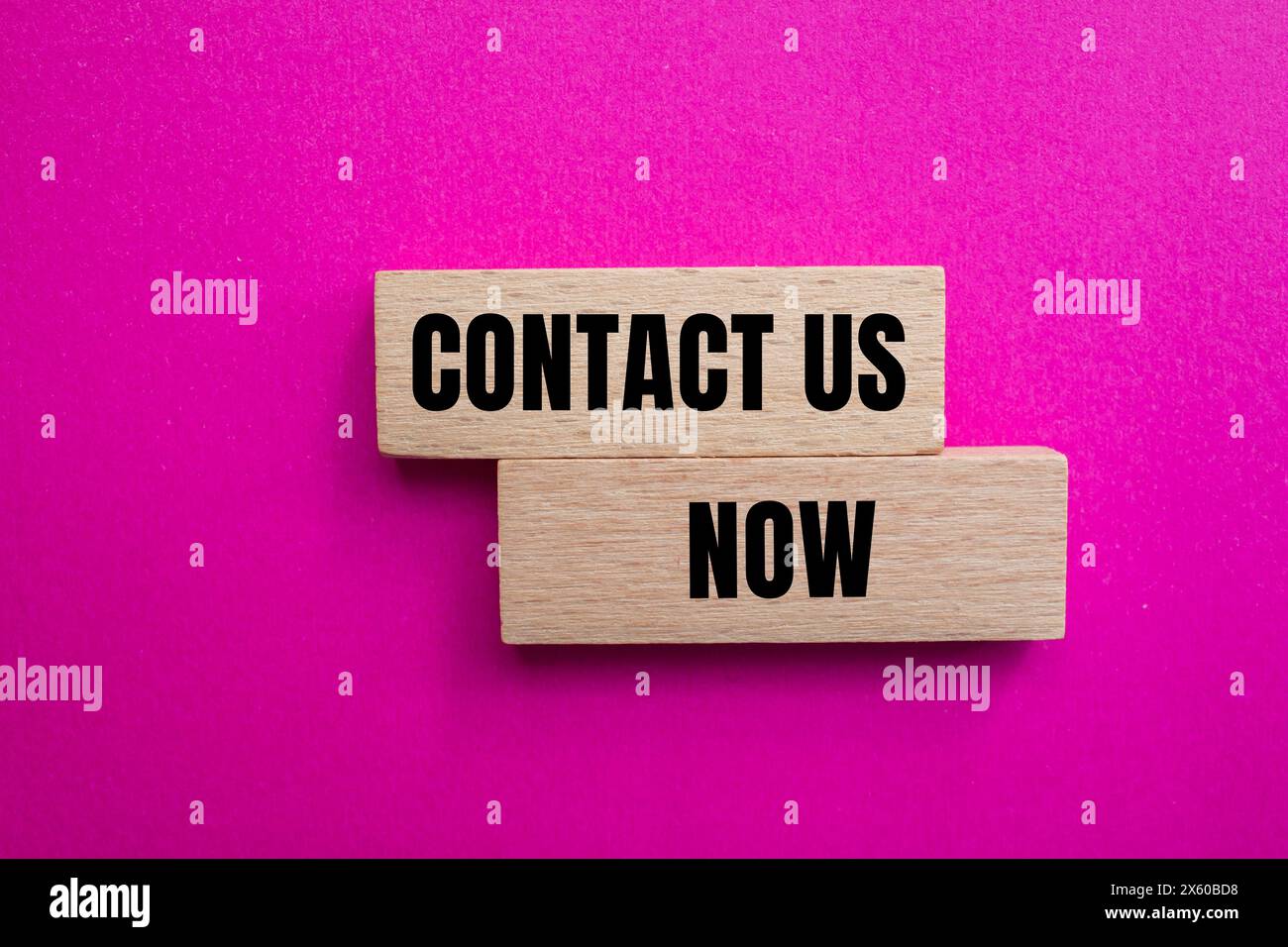 Contact us now words written on wooden blocks with pink background ...