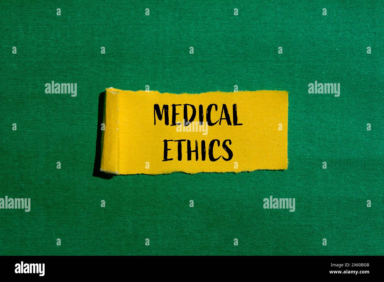 Medical ethics words written on ripped yellow paper with green ...