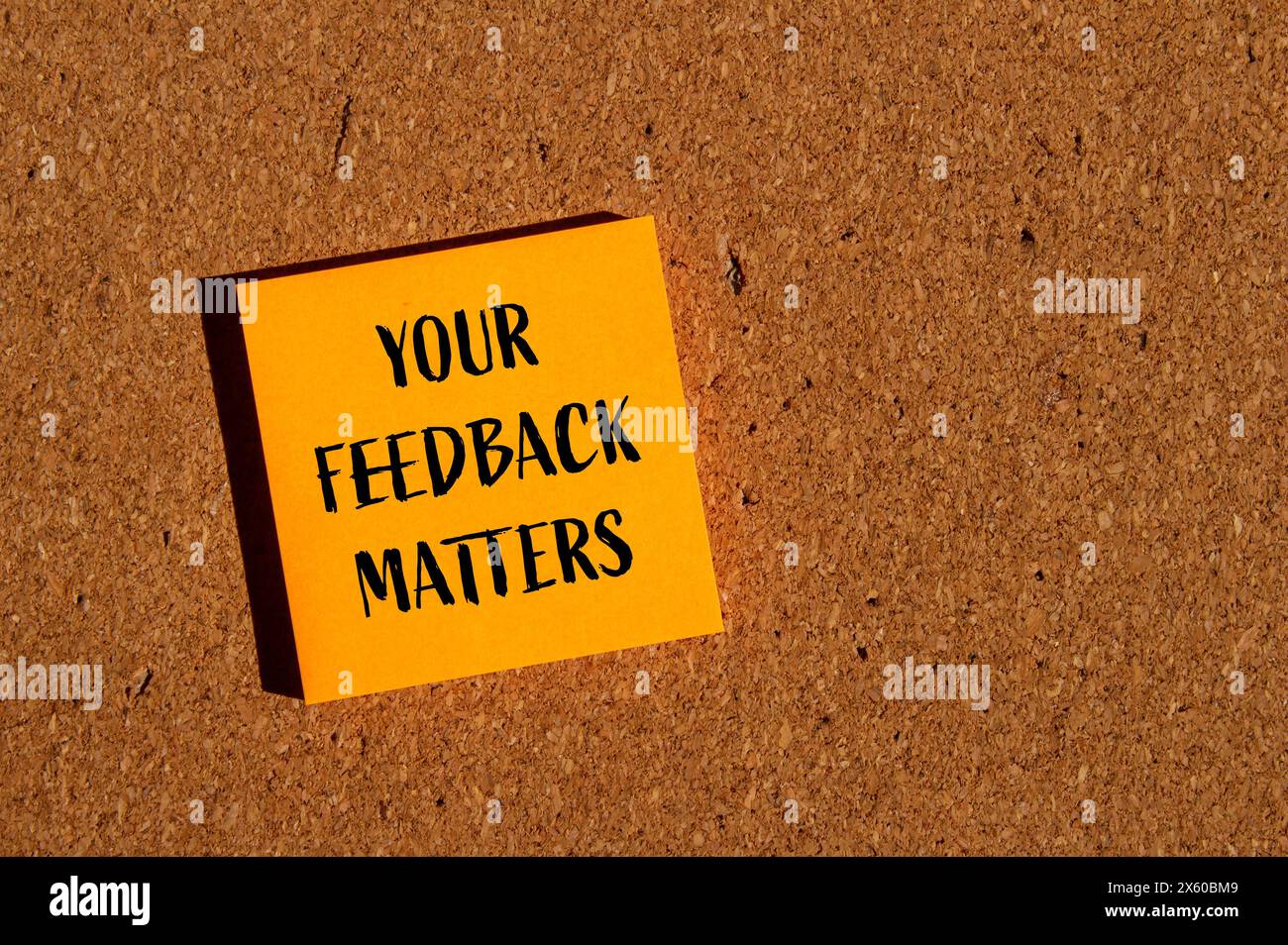 Your feedback matters words written on orange paper sticker with brown ...
