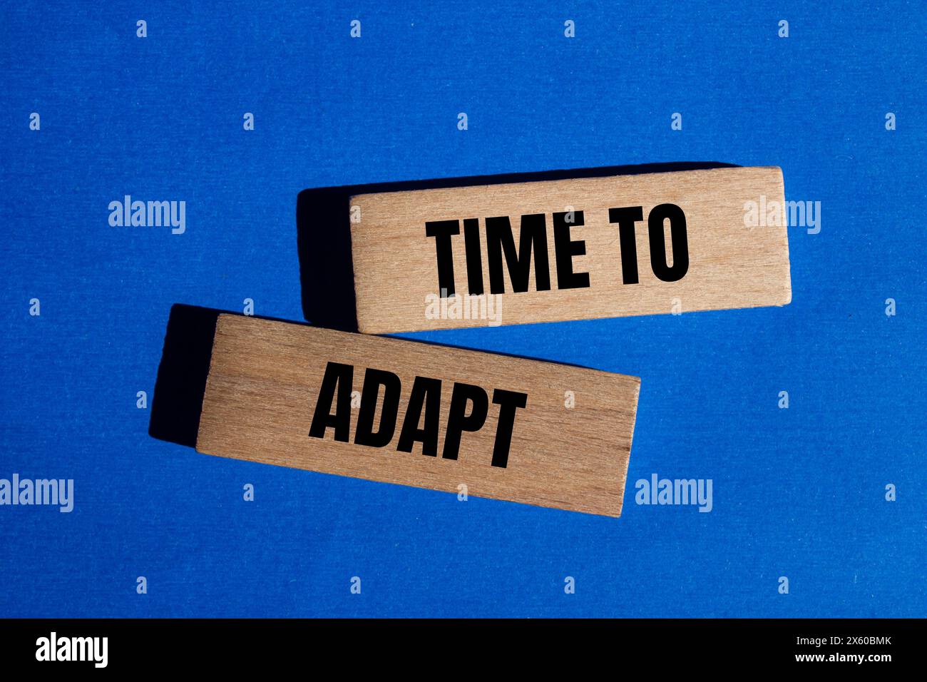 Time to adapt words written on wooden blocks with blue background ...