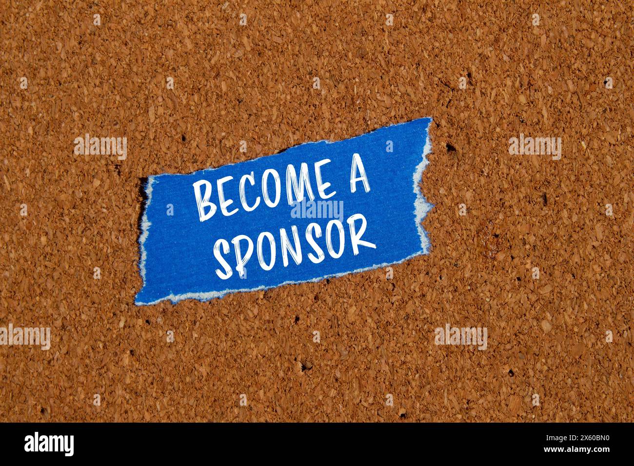 Become a sponsor words written on ripped blue paper piece with brown ...