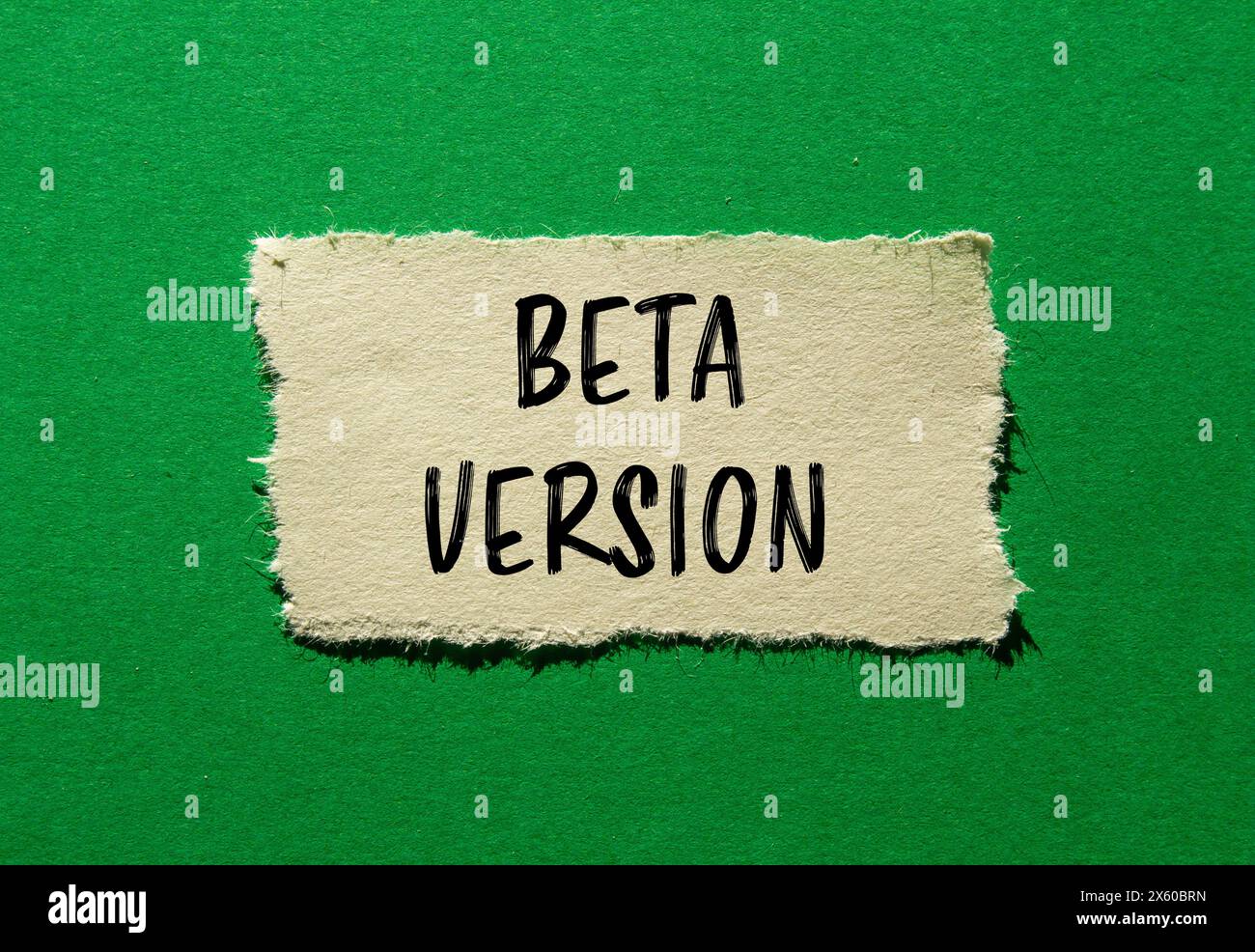 Beta version words written on ripped paper with green background ...
